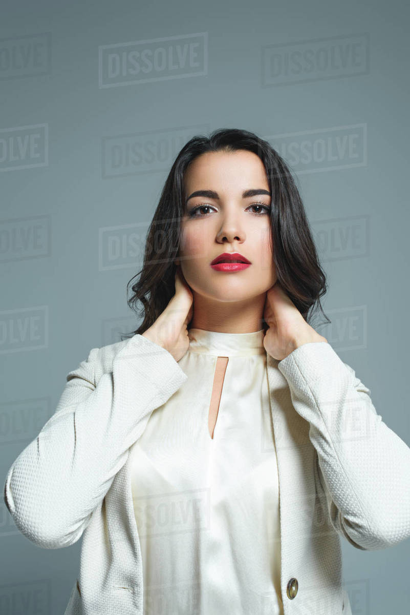 young elegant woman posing in white suit, isolated on grey - Royalty ...
