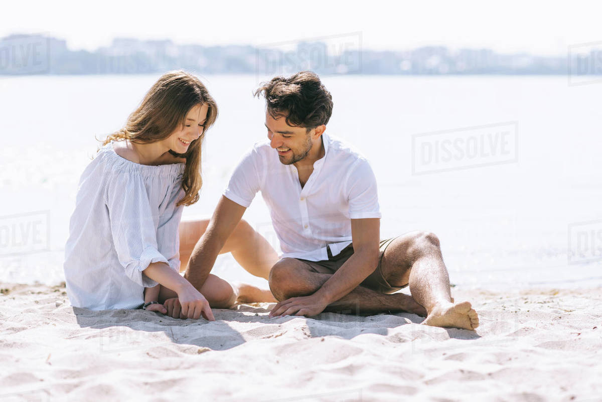 couple playing with sand on city beach near river - Royalty-free Stock ...