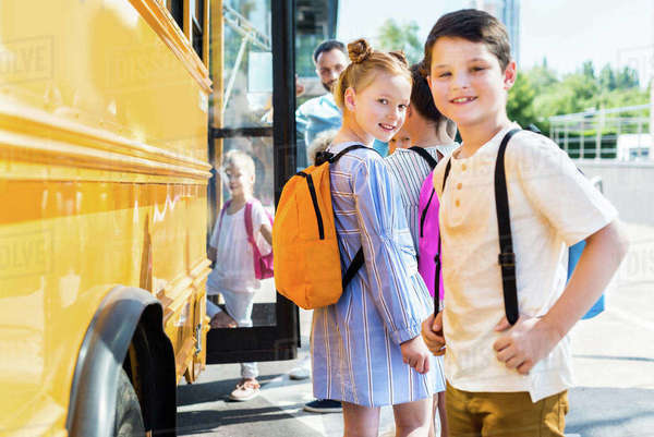 happy little pupils entering school bus with classmates - Royalty-free ...