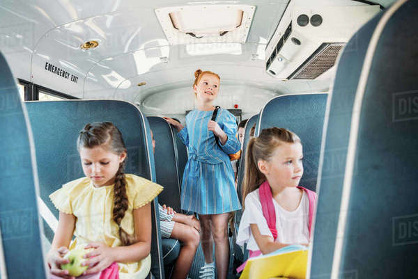 adorable little scholars riding on school bus during excursion ...