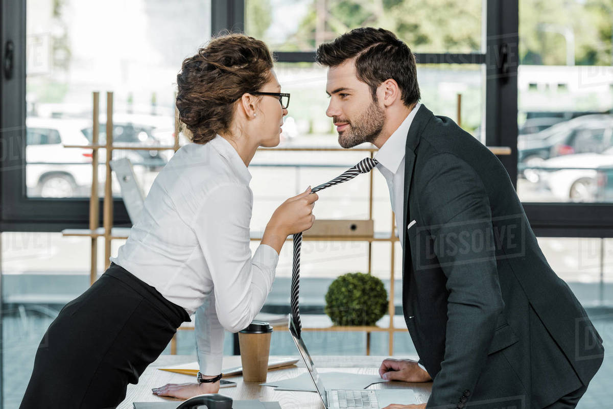 side view of businessman and businesswoman flirting at workplace in ...