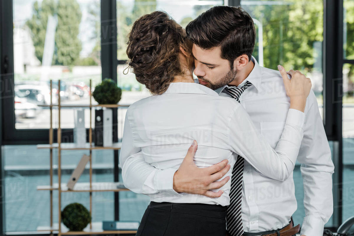 passionate business colleagues in formal wear hugging in office - Stock ...