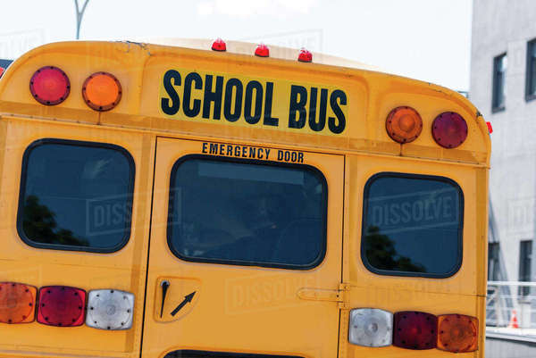 rear view of traditional school bus with inscription over back door ...
