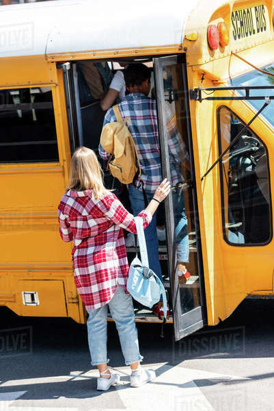 rear view of teen students walking into school bus - Royalty-free Stock ...
