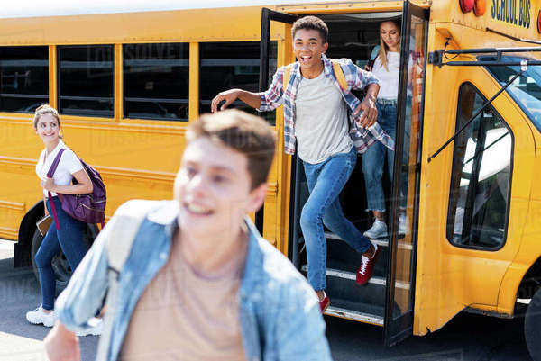 group of happy teen scholars running out school bus - Stock Photo ...