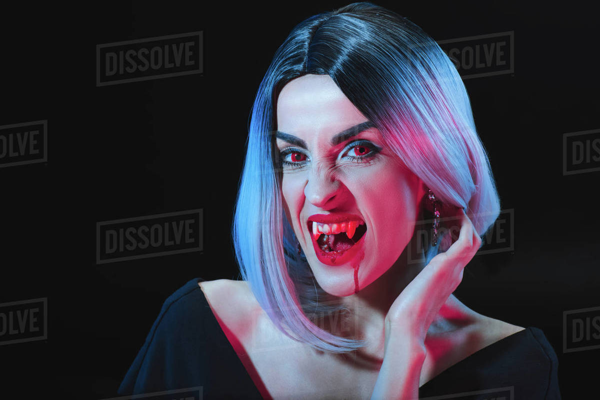 Dreadful woman showing vampire teeth isolated on black - Stock Photo ...
