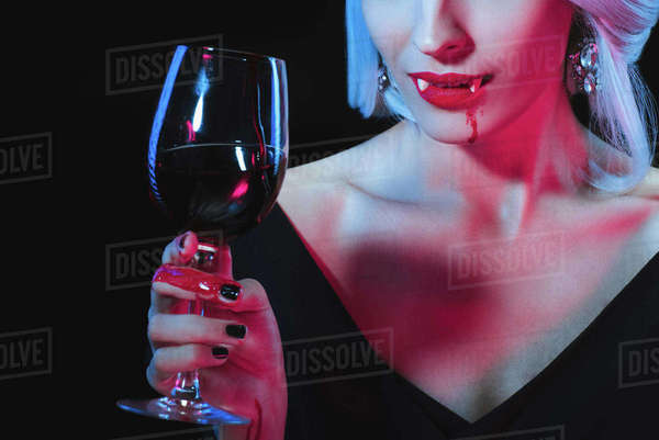 Cropped view of vampire woman holding wineglass with blood isolated on ...
