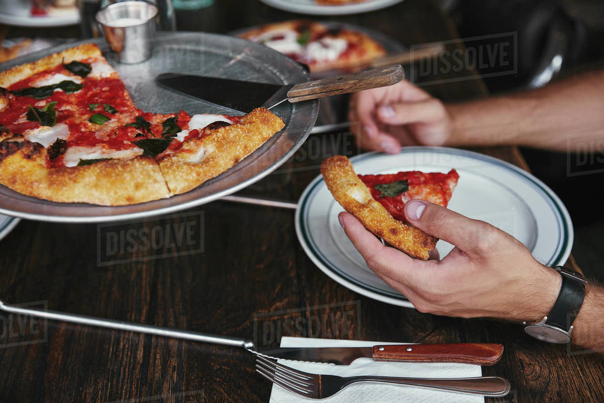 Cropped shot of man eating delicious pizza at restaurant - Royalty-free ...