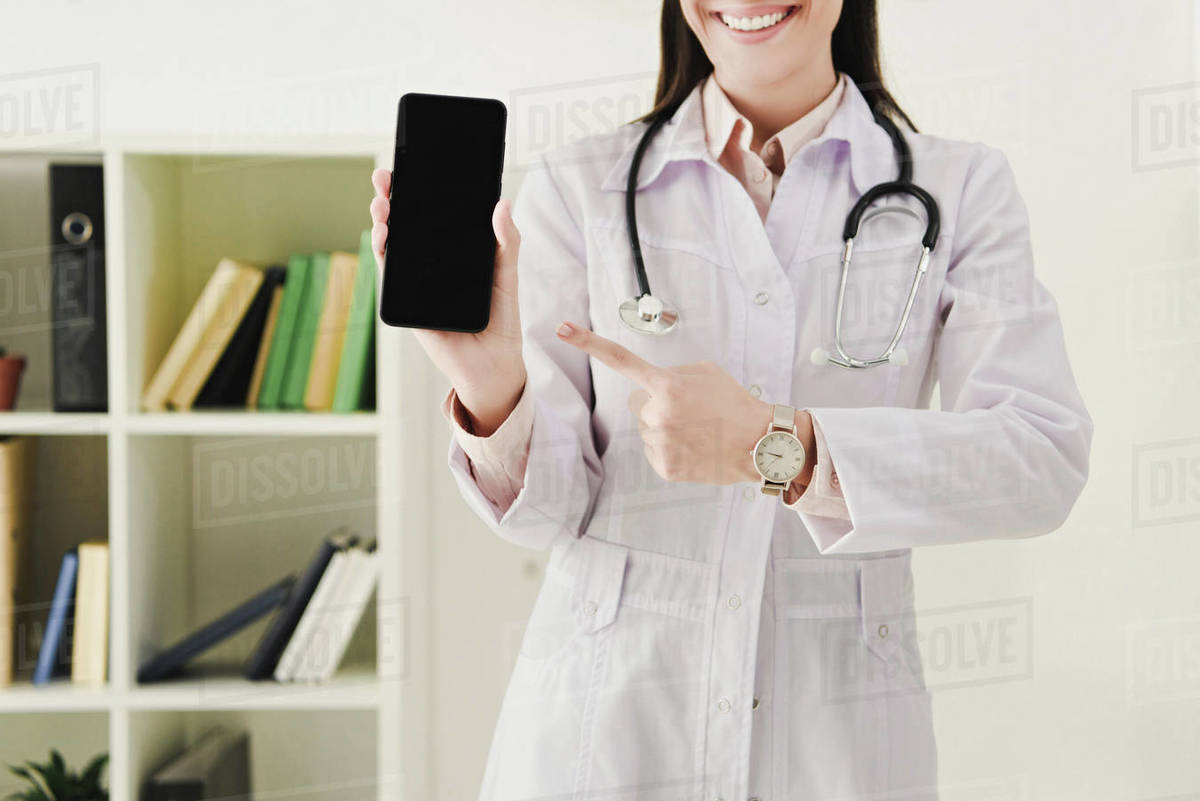 cropped view of doctor pointing at smartphone with blank screen - Stock ...