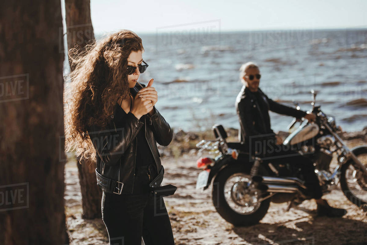 Selective focus of girlfriend smoking cigarette while boyfriend sitting ...