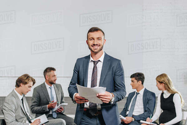 happy business coach standing in front of businesspeople at training in ...