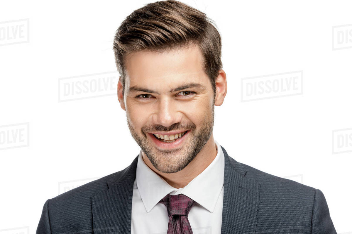 Portrait of smiling young businessman in jacket looking at camera ...