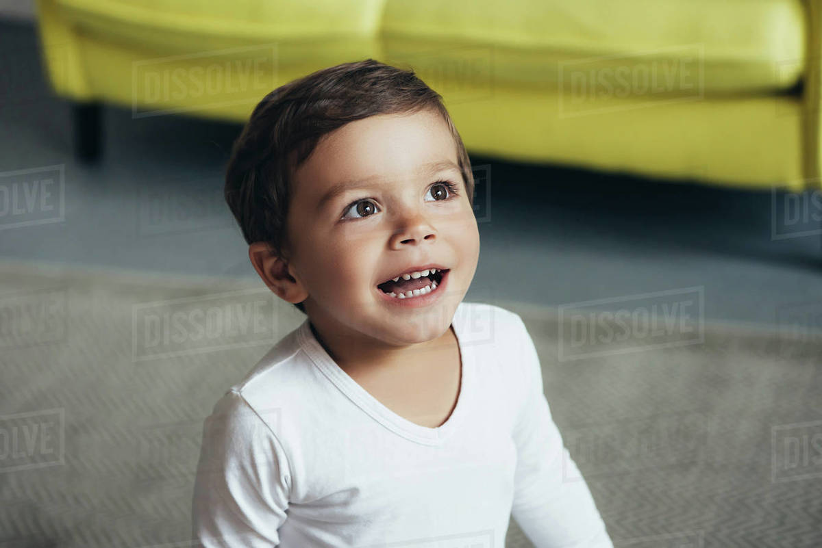 Portrait of adorable excited child at home - Stock Photo - Dissolve