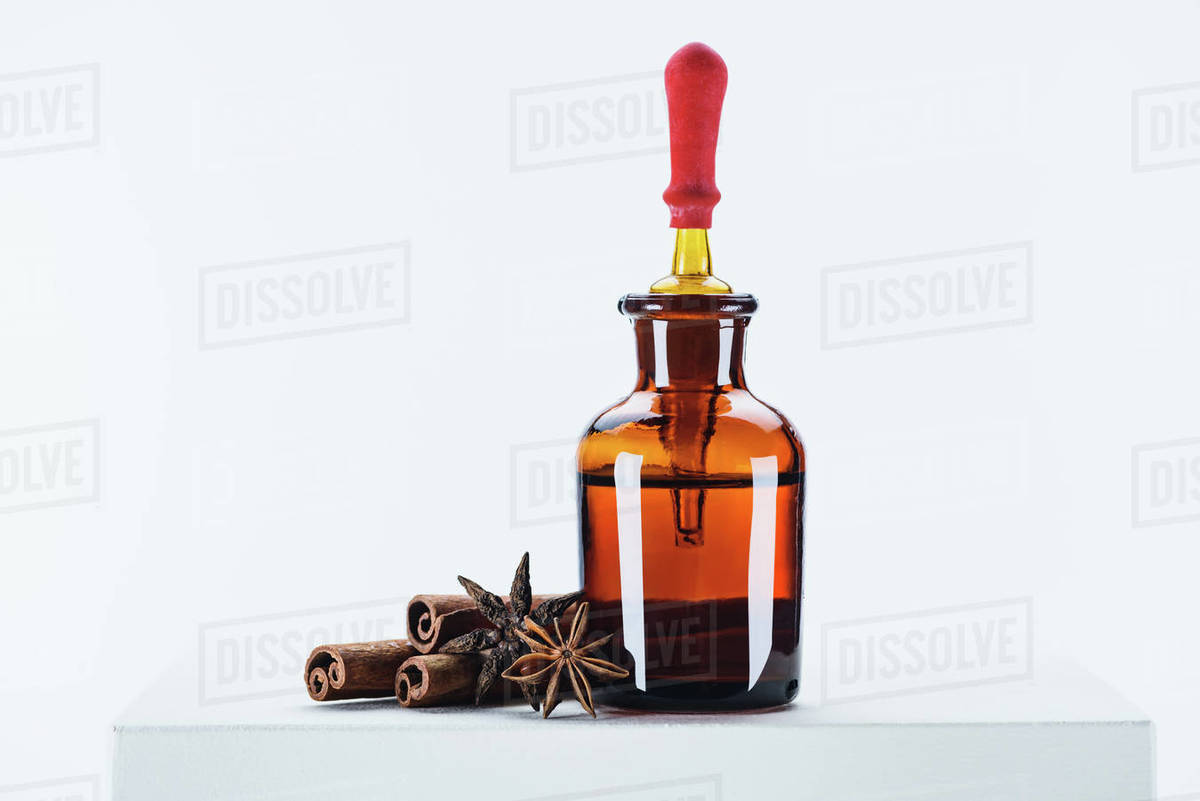 Bottle of natural herbal essential oil, dropper and carnation with ...