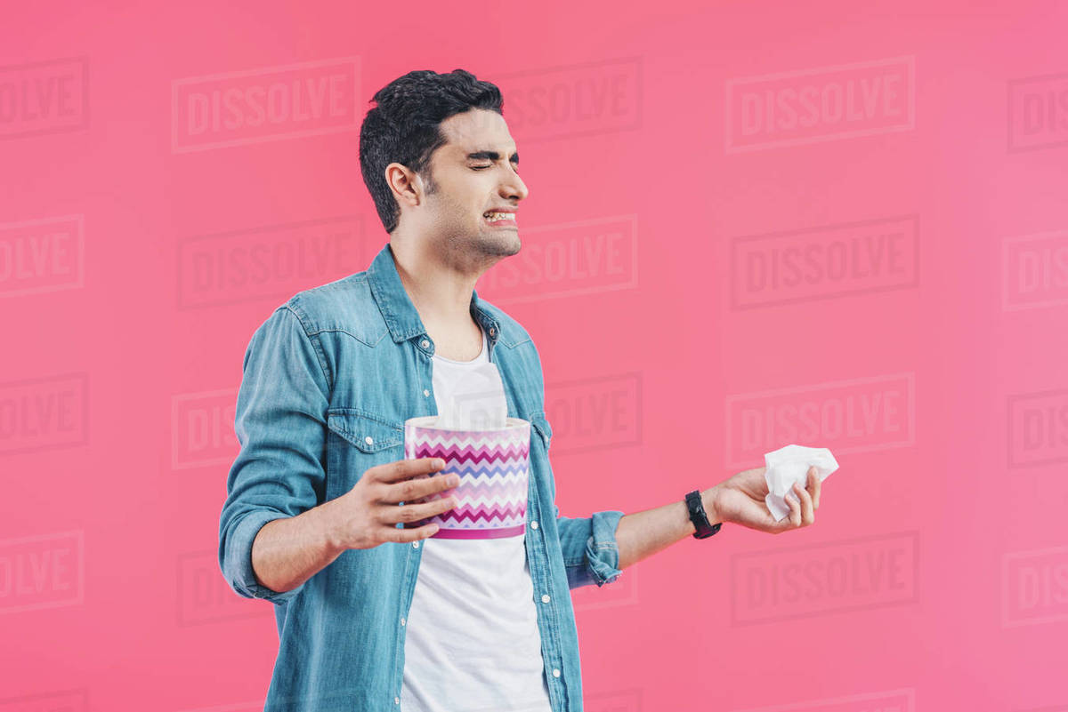 Emotional young man with tissue box crying and gesturing by hands ...