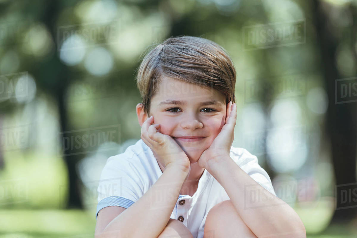 Portrait of cute happy little boy smiling at camera in park - Royalty ...