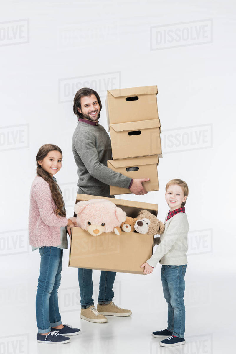 Happy children holding cardboard box with toys while father carrying ...