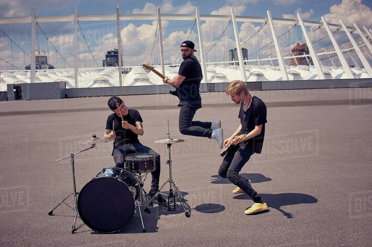 Rock band in black clothing playing music on street - Royalty-free ...