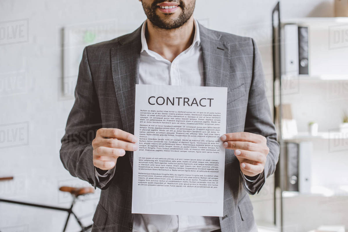 Cropped image of cheerful businessman showing contract in office ...
