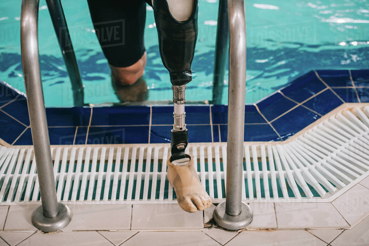 Cropped shot of swimmer with artificial leg getting out of swimming ...