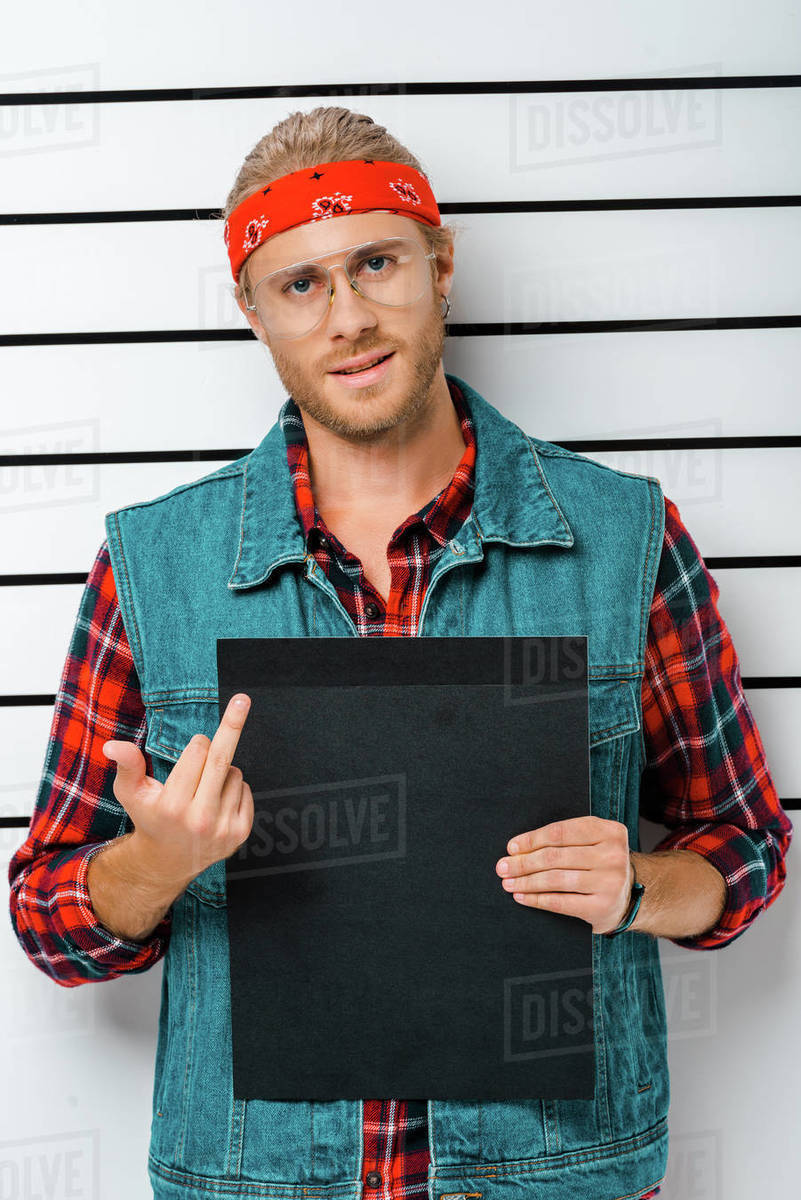 arrested hipster man in eyeglasses showing middle finger and holding ...