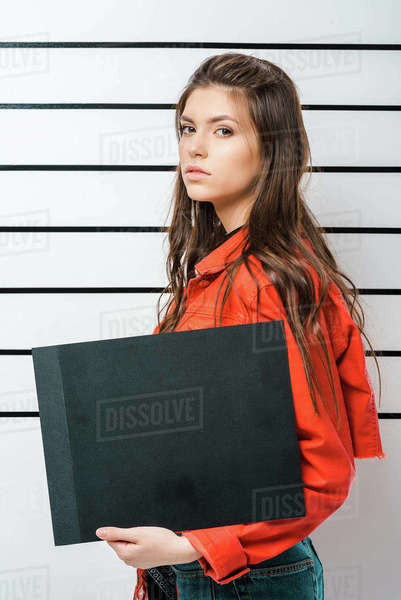 arrested young woman posing with empty prison board in front of police ...
