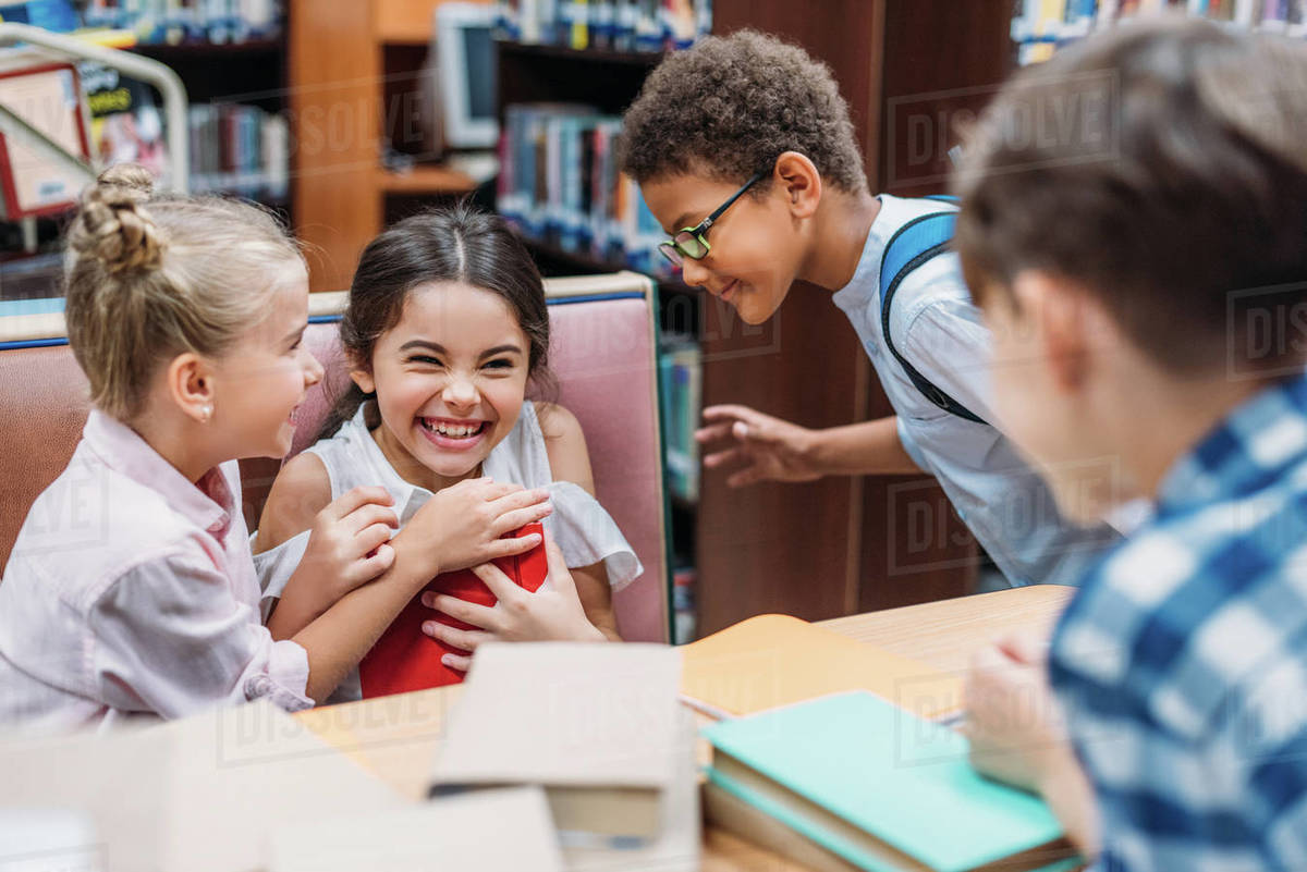 laughing kids having fun in library - Royalty-free Stock Photo | Dissolve