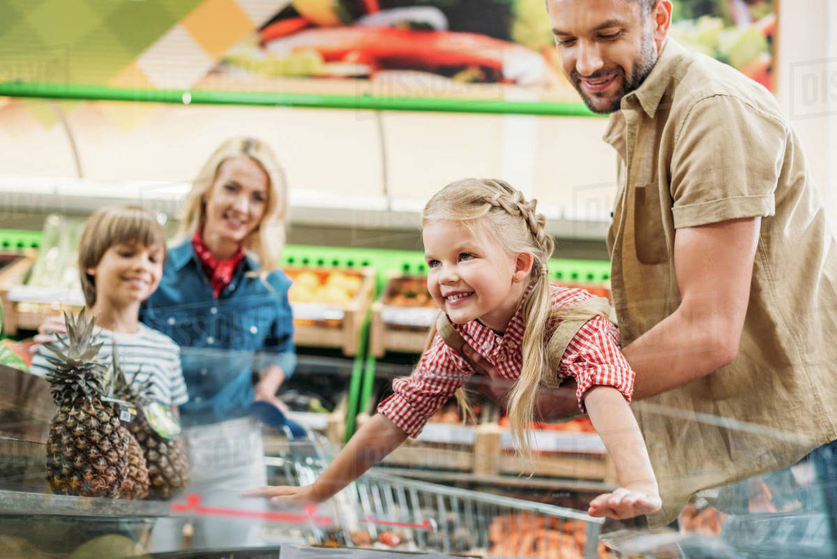 happy young family shopping together in supermarket - Stock Photo ...
