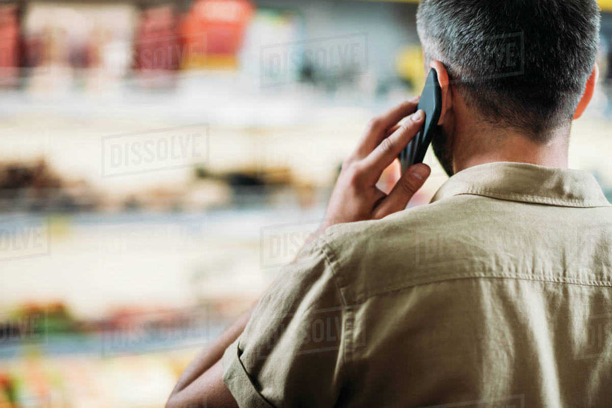 back view of man talking on smartphone - Stock Photo - Dissolve
