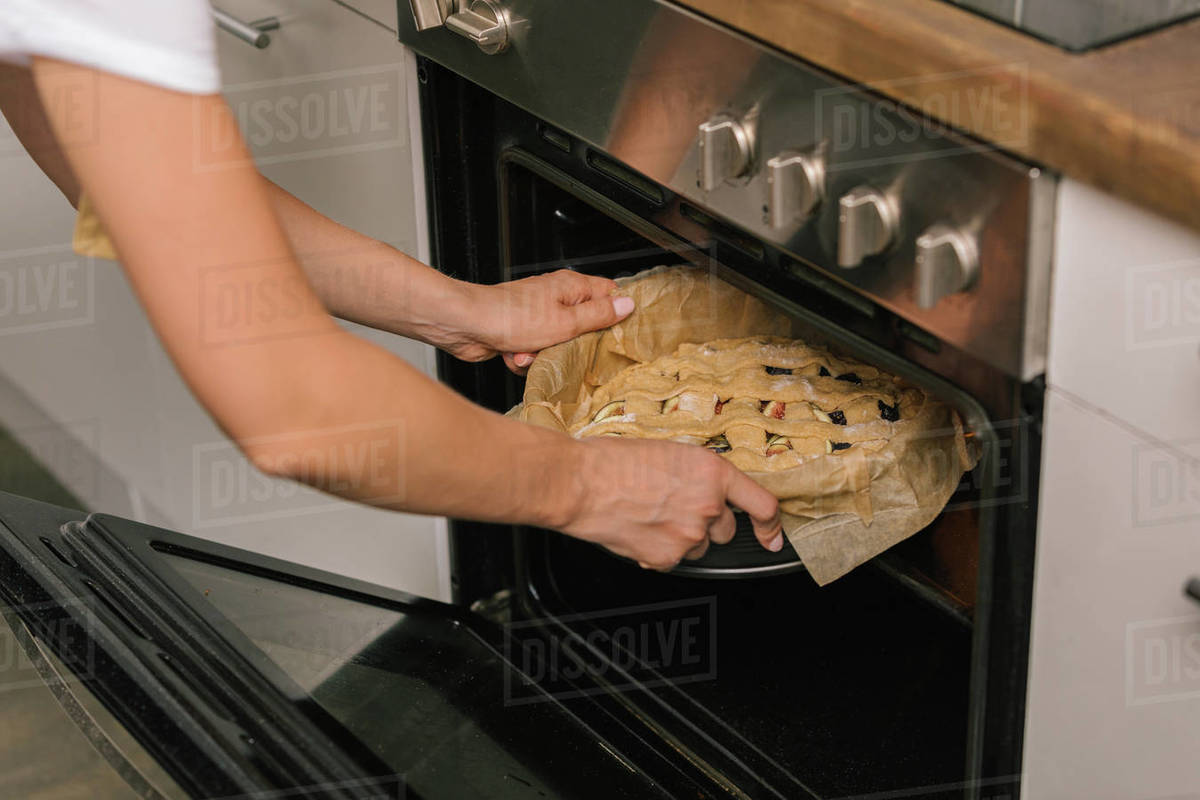 Cropped shot of woman putting pie into oven - Royalty-free Stock Photo ...