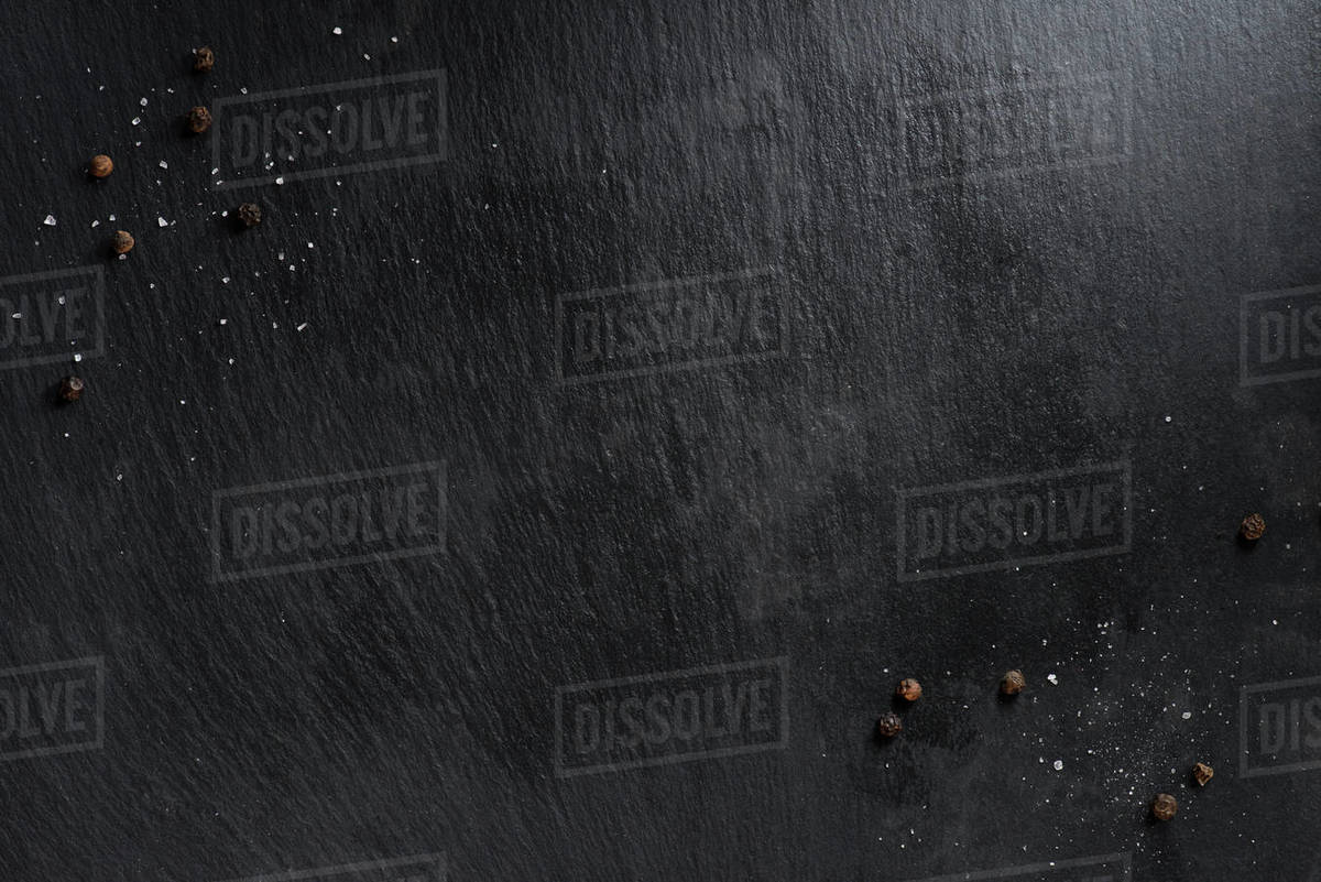 Top view of scattered peppers and salt on dark tabletop - Stock Photo ...