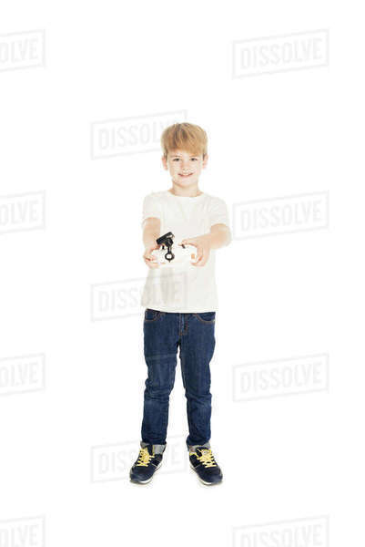Adorable boy holding remote control isolated on white and looking at ...