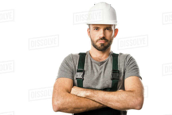 Handsome plumber in helmet standing with crossed arms and looking at ...