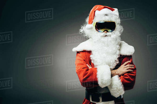 Confident Santa Claus in ski mask standing with crossed arms isolated ...