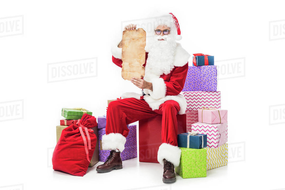 Santa Claus showing empty old parchment and sitting on pile of gift ...