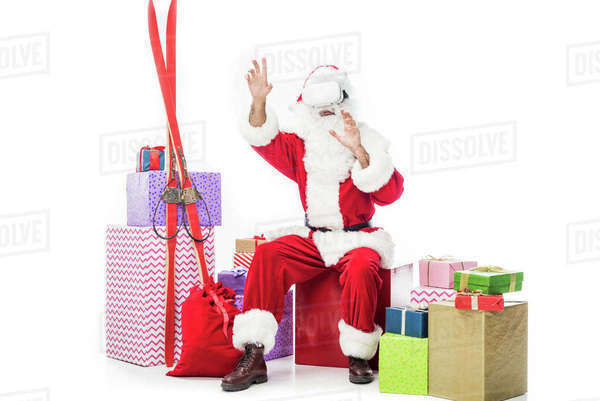Santa Claus wearing virtual reality headset and sitting on pile of gift ...