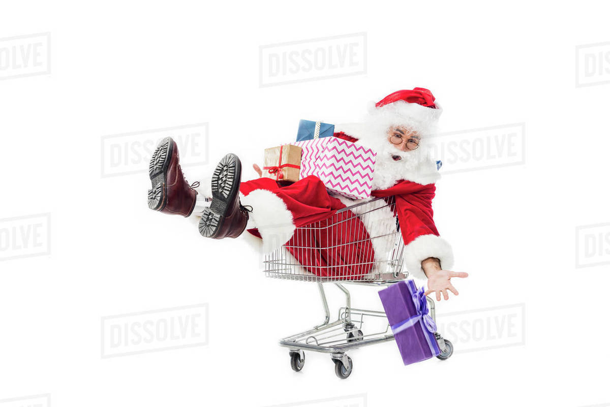 Santa Claus throwing gift box from trolley isolated on white background ...