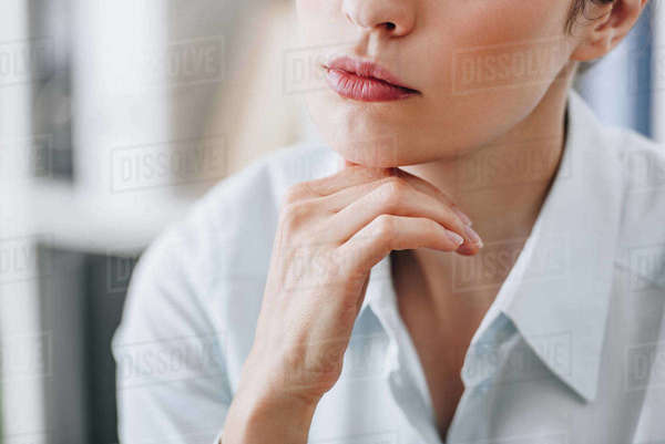 Cropped shot of businesswoman touching chin with hand at office ...