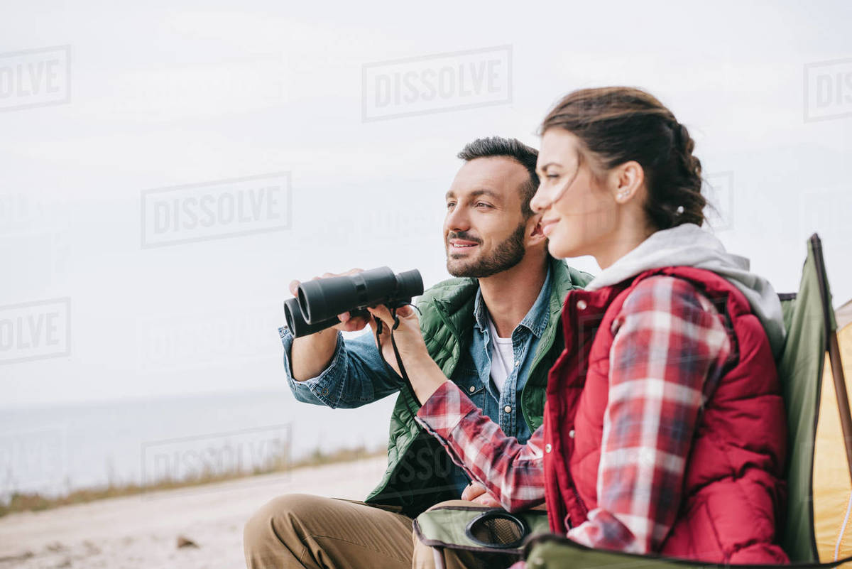 Side view of couple with binoculars having camping - Royalty-free Stock ...