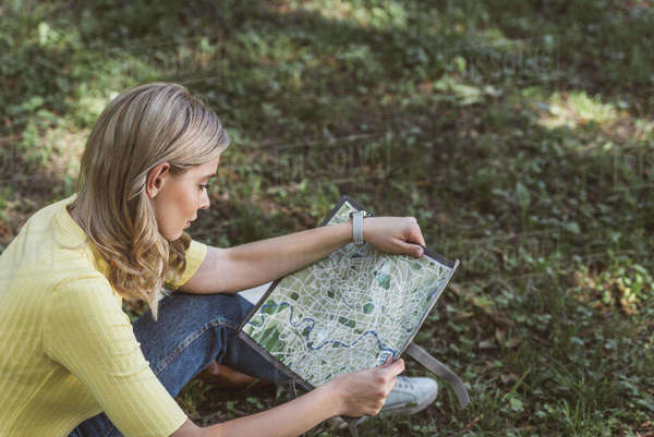 Young tourist looking for destination on map in park - Royalty-free ...