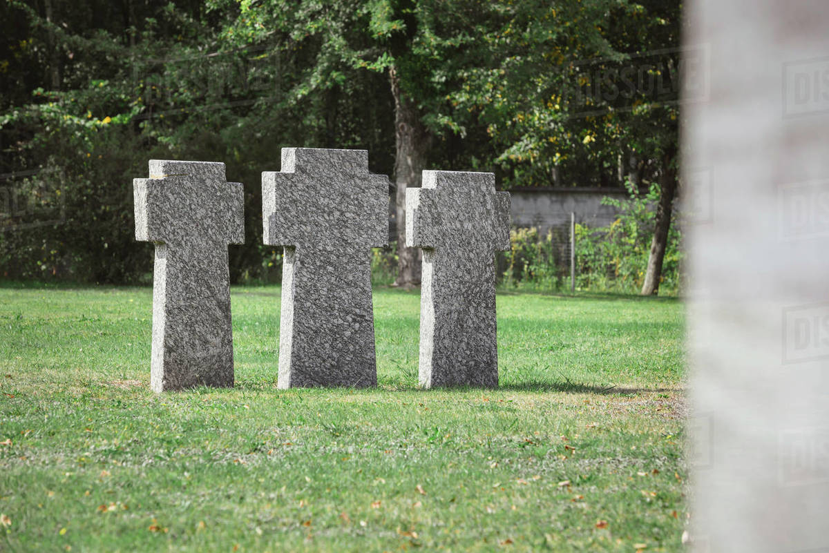 old identical tombstones placed in row on grass at cemetery - Royalty ...