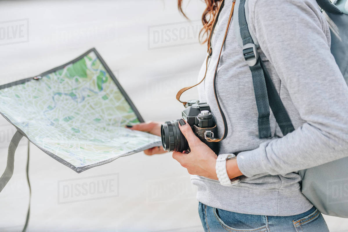 Cropped view of traveler holding photo camera and map in city - Royalty ...