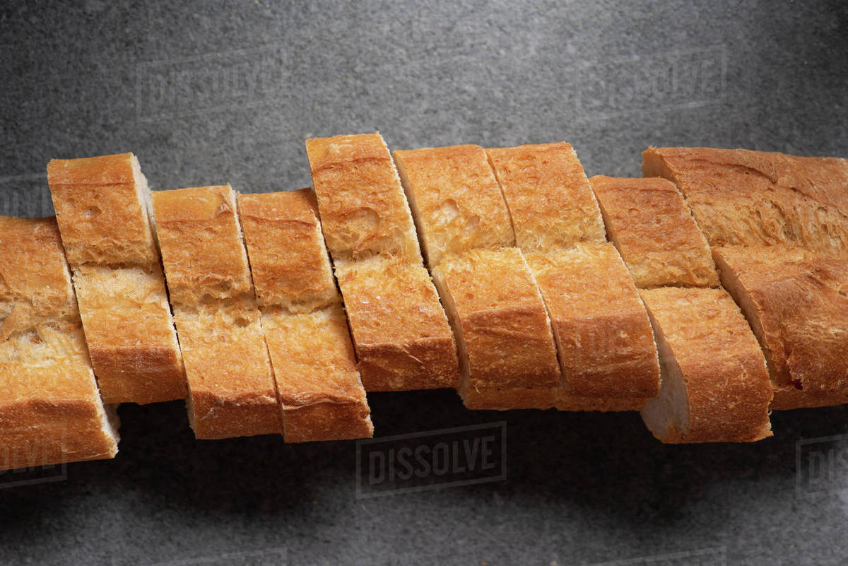 Top view of cut baguette on grey surface - Royalty-free Stock Photo ...