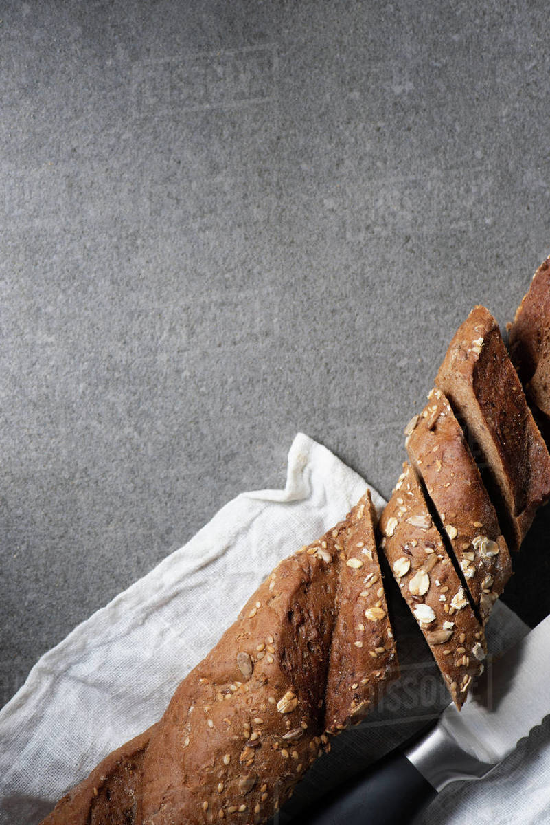 Top view of cut baguette in white linen on grey tabletop - Royalty-free ...