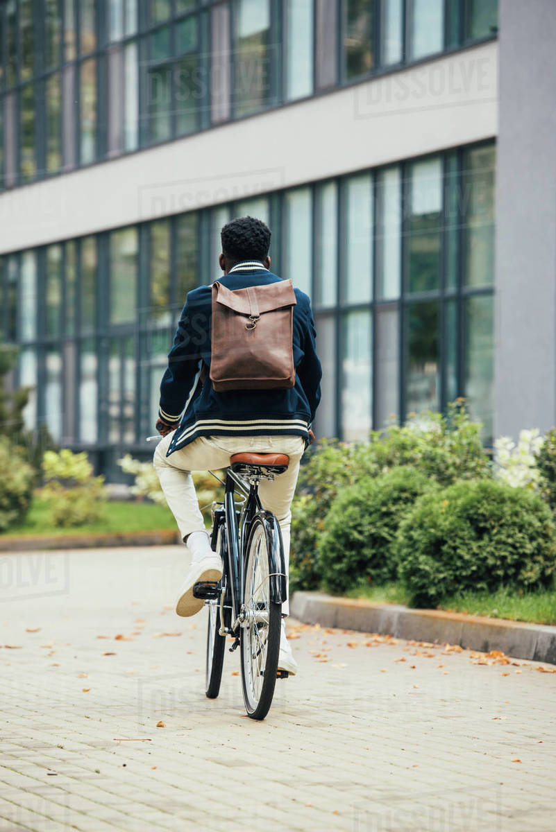 Back view of African American man riding bike in city - Royalty-free ...