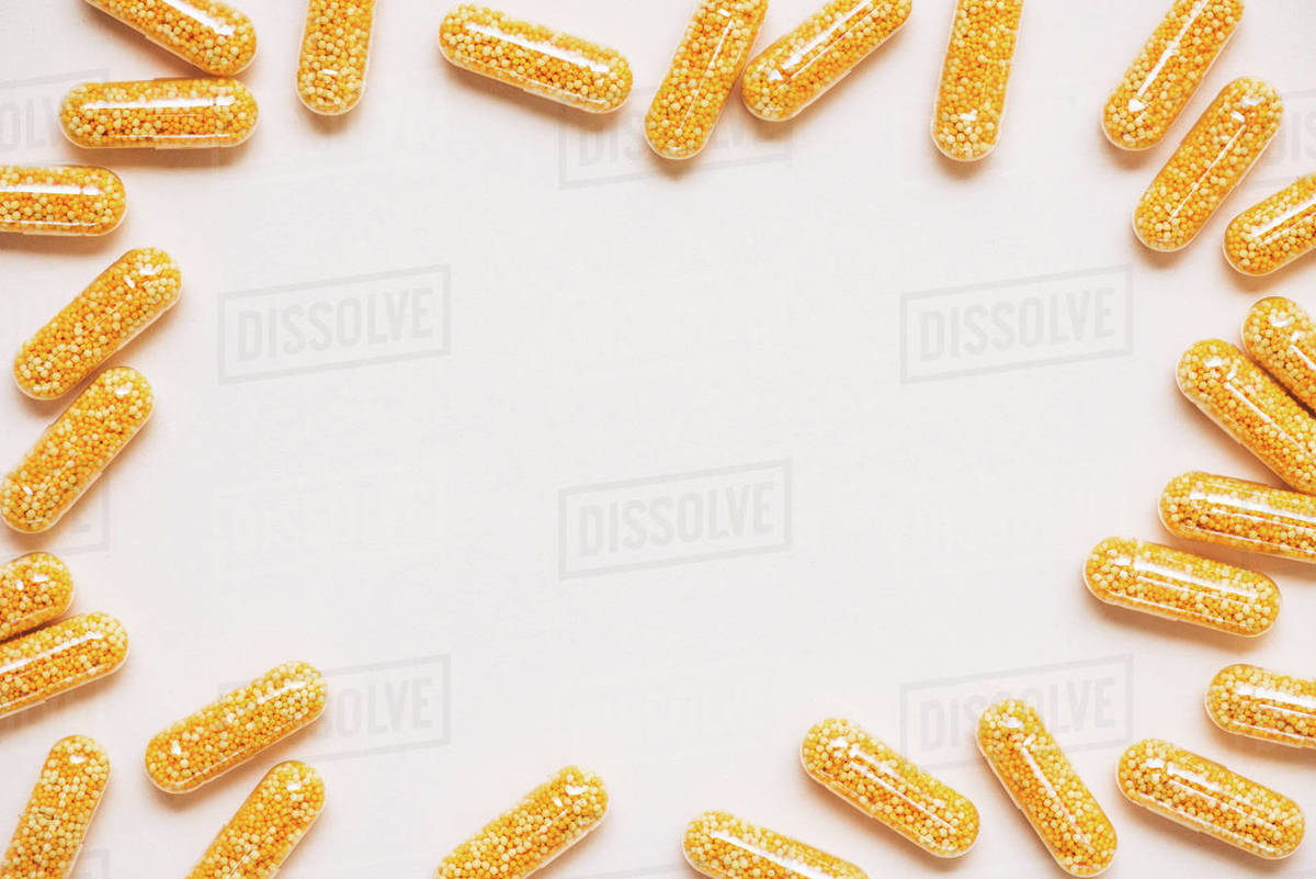 Top view of frame made of yellow medical capsules on white - Royalty ...
