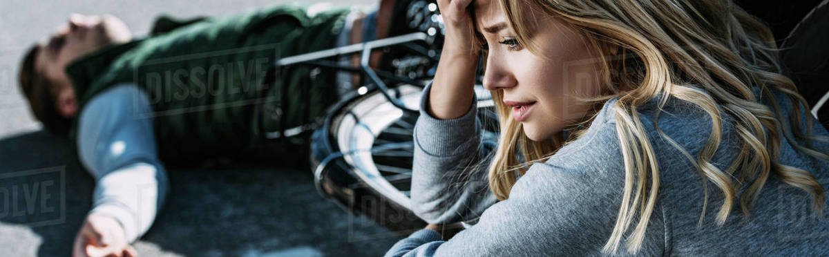 Scared young woman crying near car after traffic collision with cyclist ...