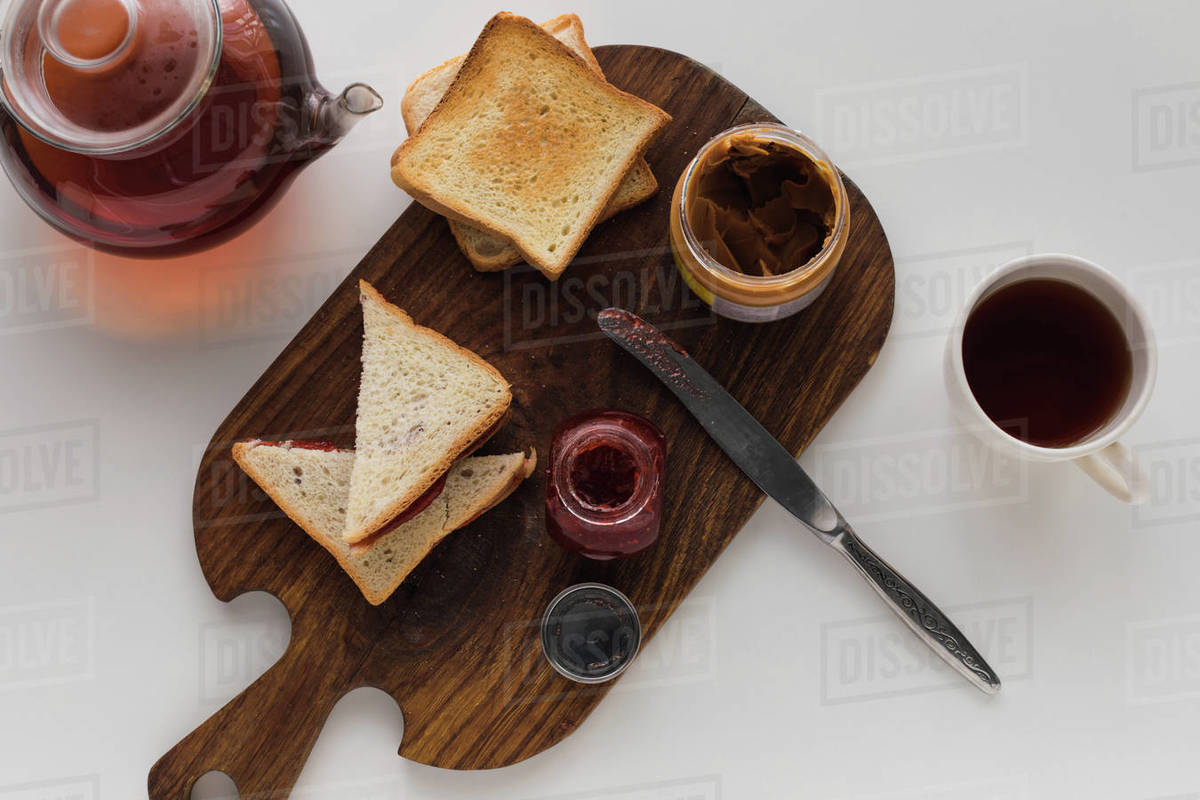 Top view of tea and toasts with jam and peanut butter for breakfast ...