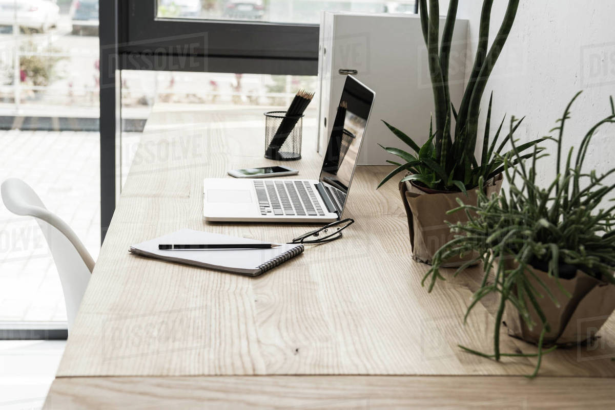 Side view of workplace with laptop computer in modern office - Royalty ...