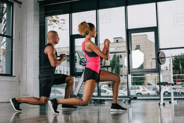Side view of young African American couple of athletes exercising at ...